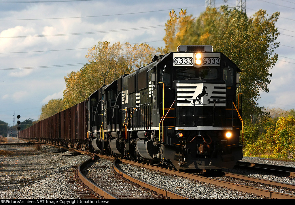 A trio of consecutively numbered SD40E's (6333, 6332 and 6331) lead a Herzog ballast train east ...